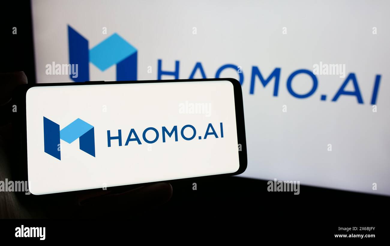 Person holding smartphone with logo of Chinese autonomous driving ...