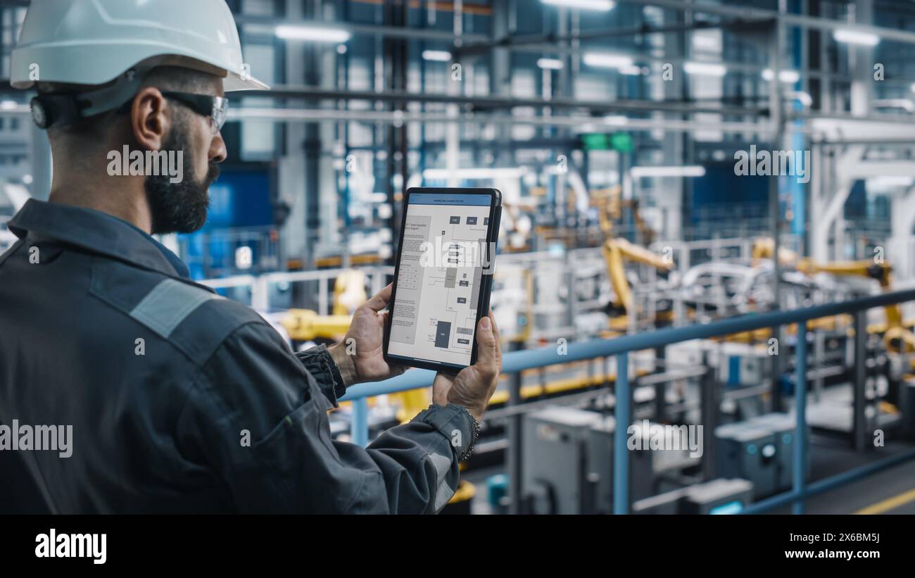 Car Factory Engineer in Work Uniform Using Tablet Computer with ...