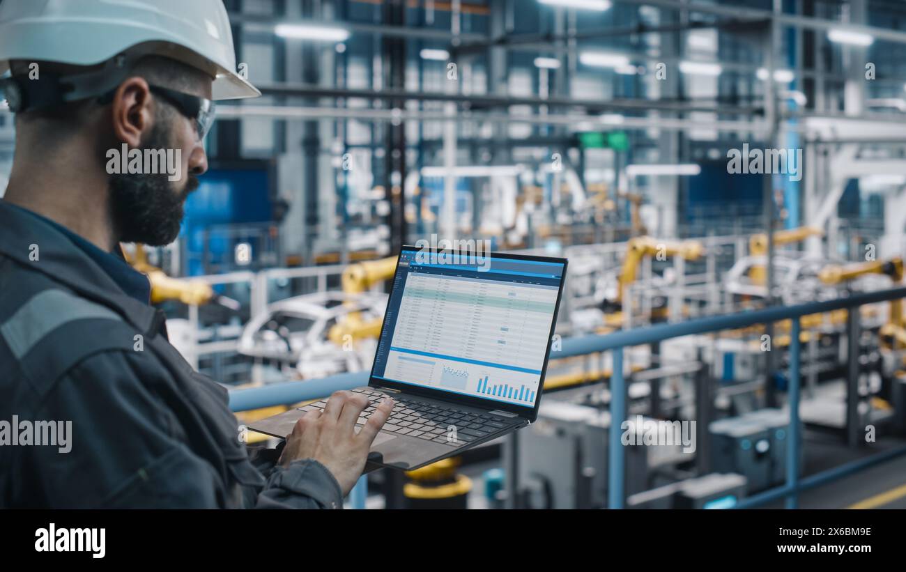 Car Factory Engineer in Work Uniform Using Laptop Computer with ...
