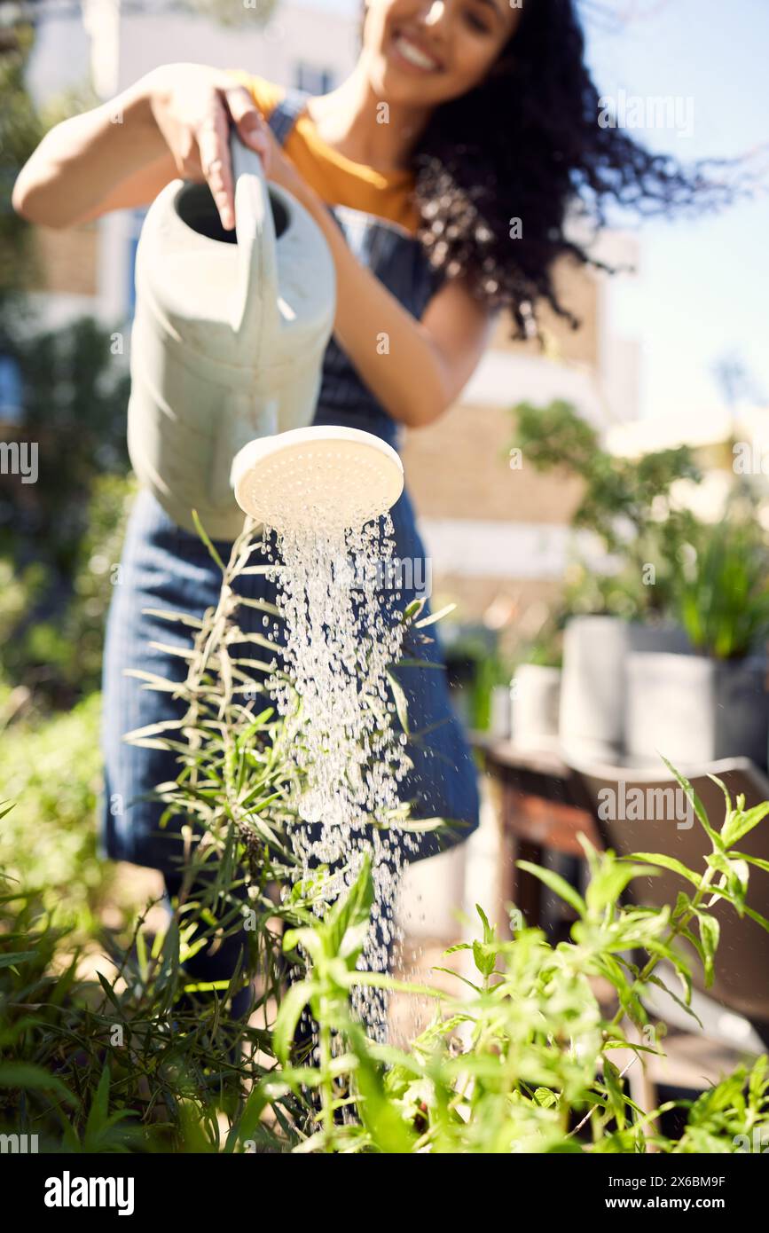 Outdoor, smile and water for plants, woman and entrepreneur with apron, spring and growth of ...