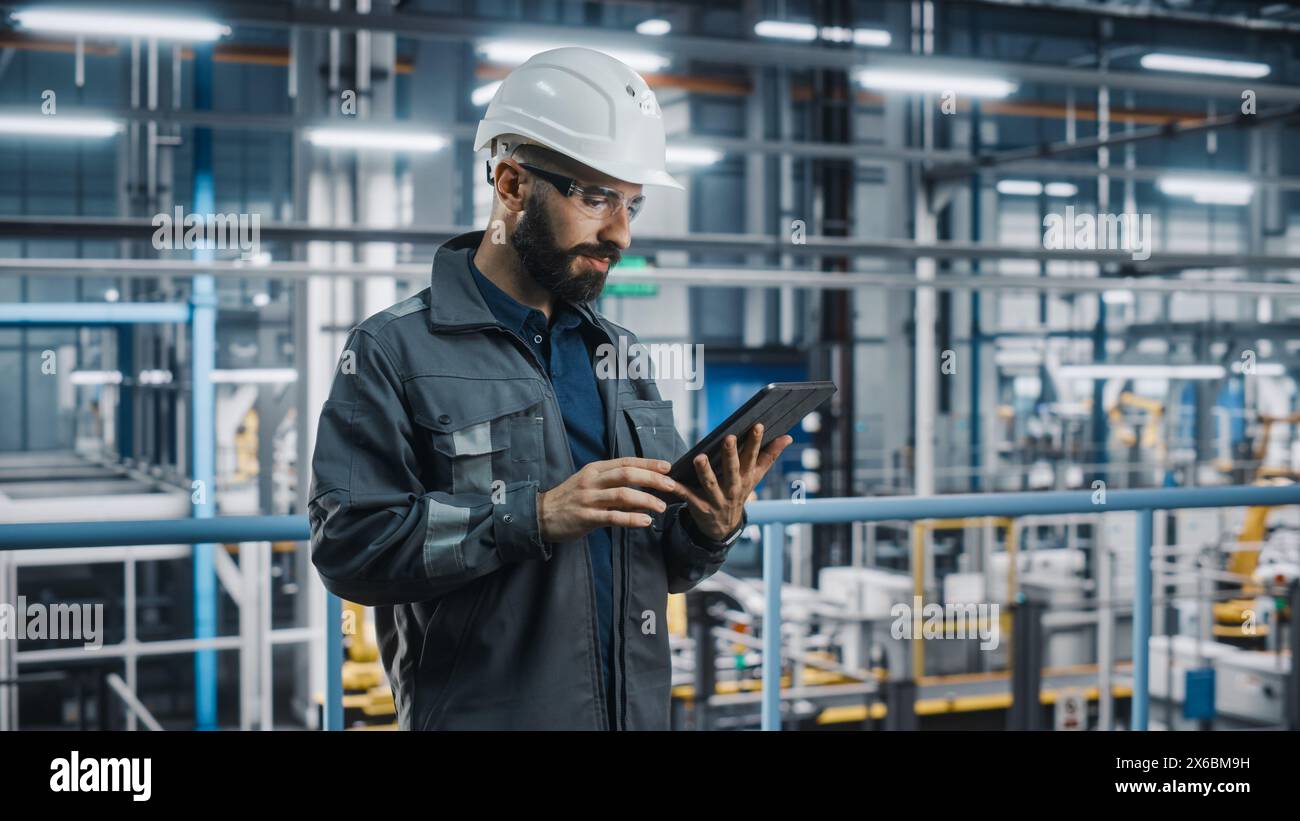 Car Factory Engineer in Work Uniform Using Tablet Computer. Automotive ...