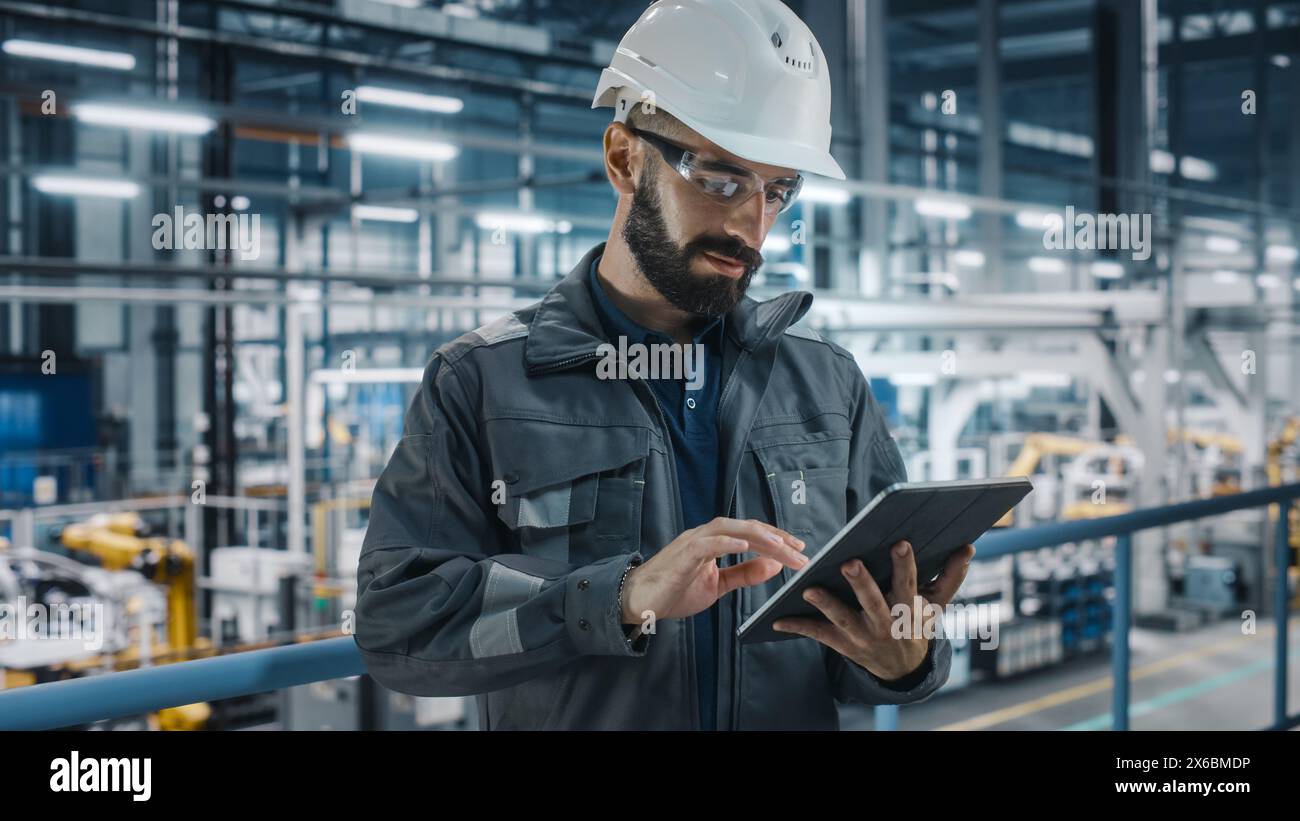 Car Factory Engineer in Work Uniform Using Tablet Computer. Automotive ...