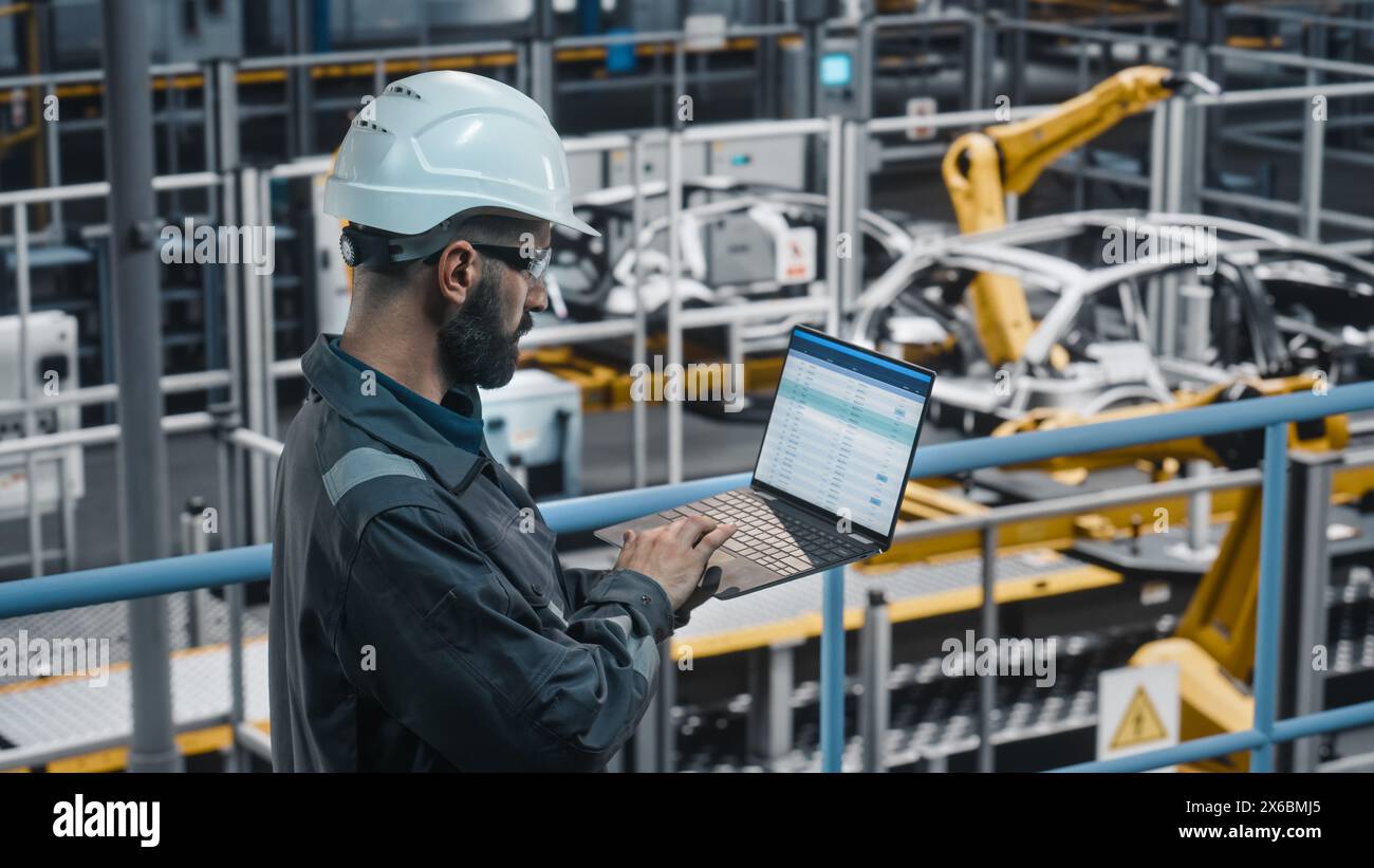 Car Factory Engineer in Work Uniform Using Laptop Computer with ...