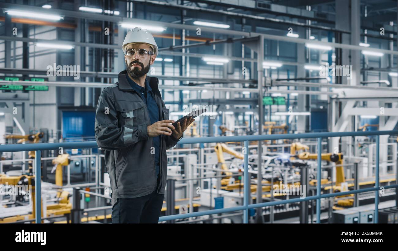 Car Factory Engineer in Work Uniform Using Tablet Computer. Automotive ...