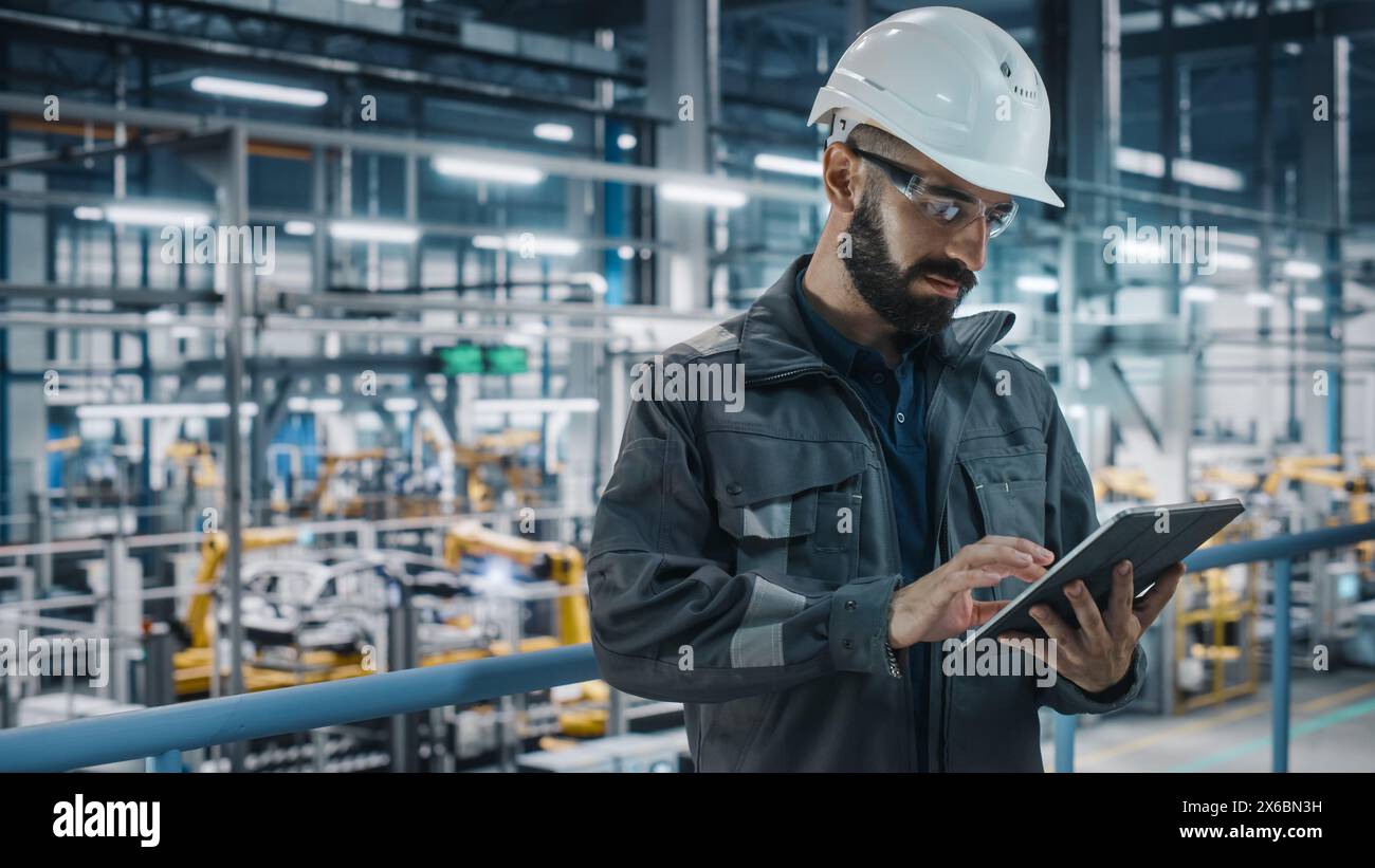 Car Factory Engineer in Work Uniform Using Tablet Computer. Automotive ...