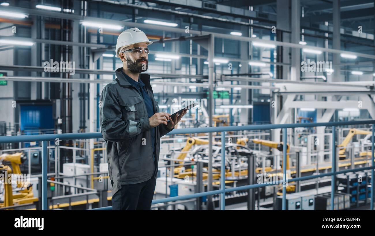 Car Factory Engineer in Work Uniform Using Tablet Computer. Automotive ...