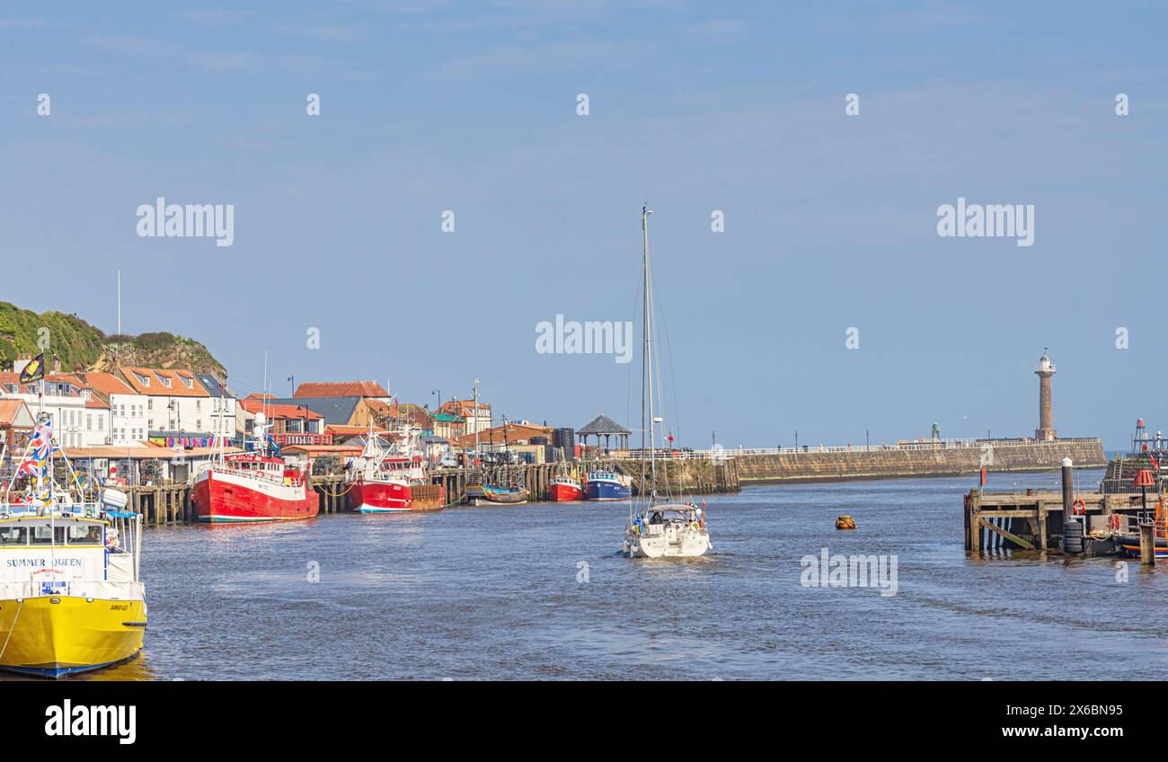 Whitby harbour with a tour boat moored alongside a wharf. Buildings ...