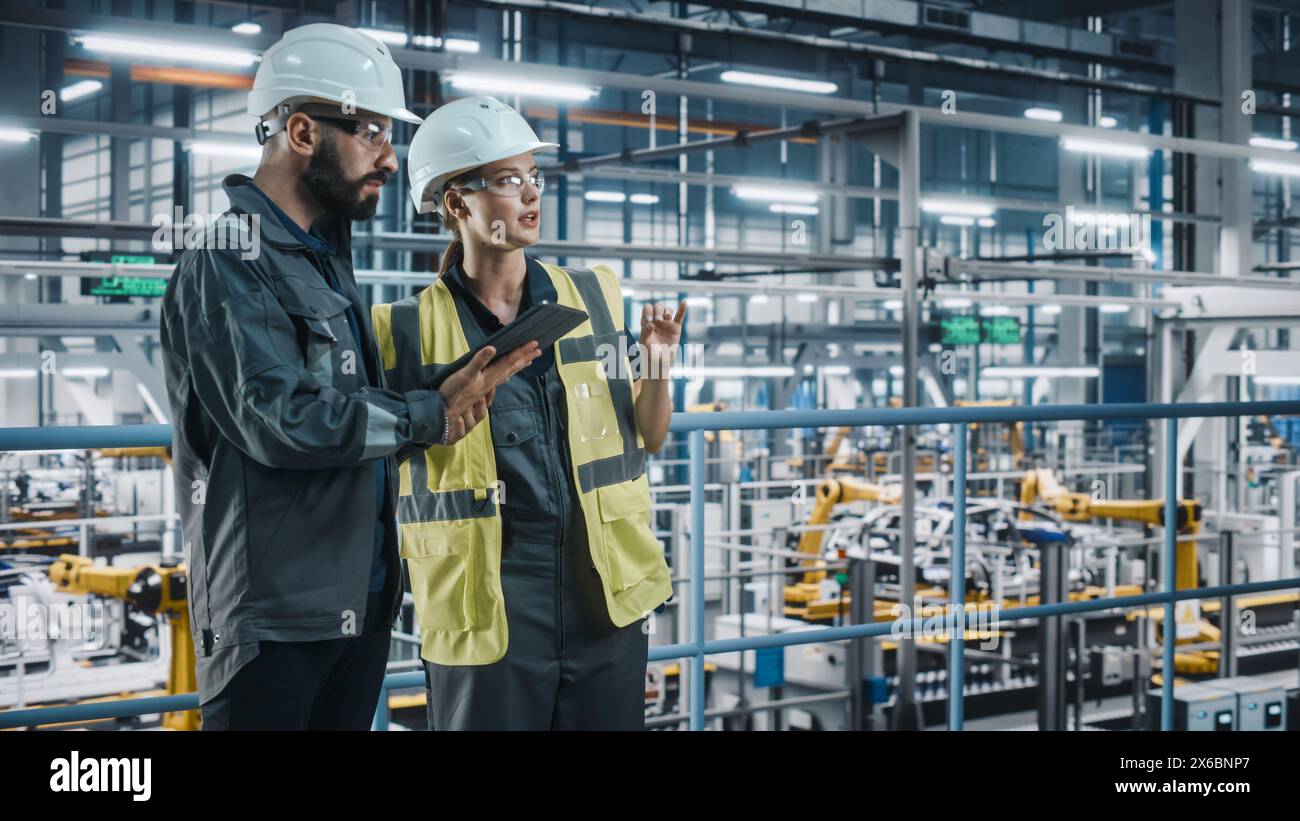 Male Specialist and Female Car Factory Engineer in High Visibility ...