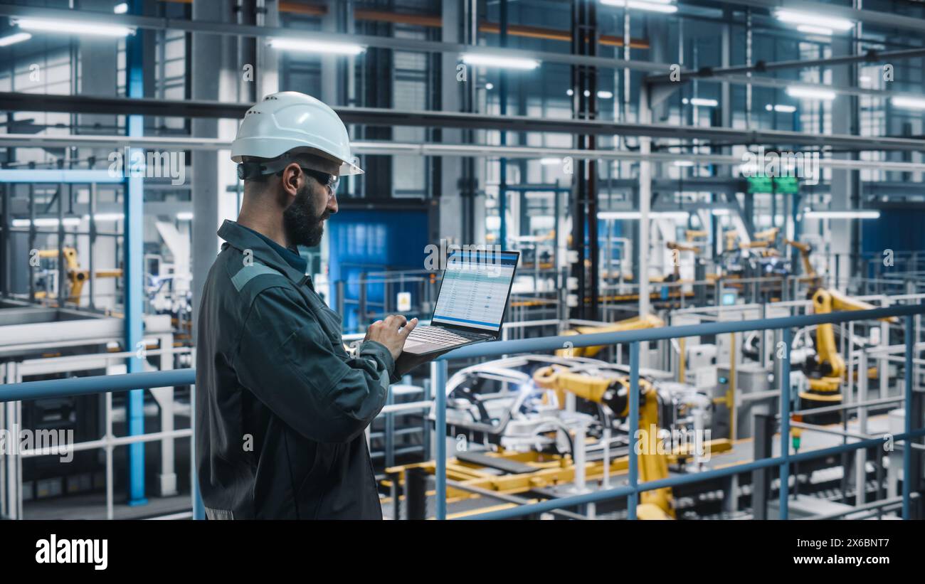 Car Factory Engineer in Work Uniform Using Laptop Computer with ...
