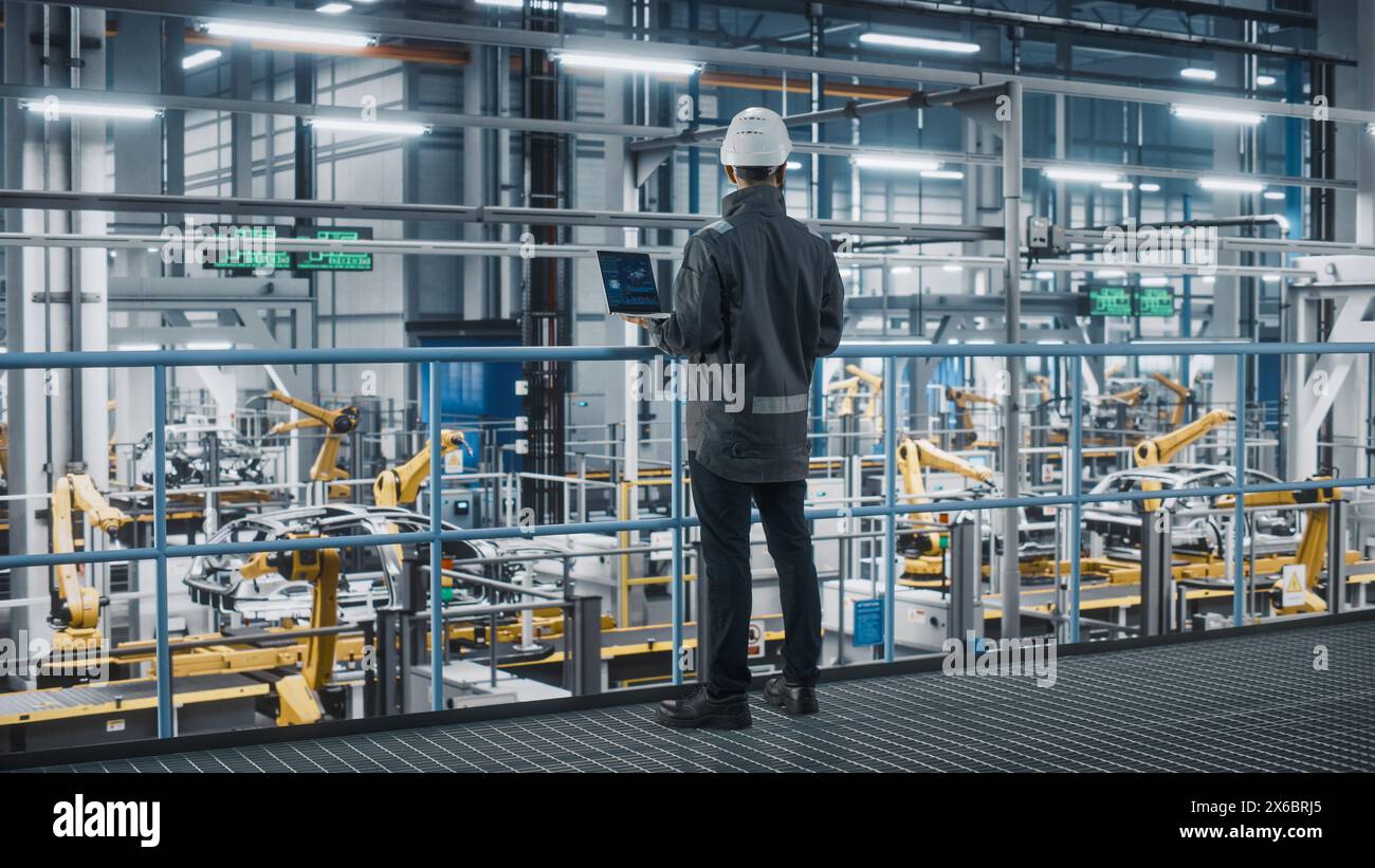 Car Factory Engineer in Work Uniform Using Laptop Computer. Automotive ...