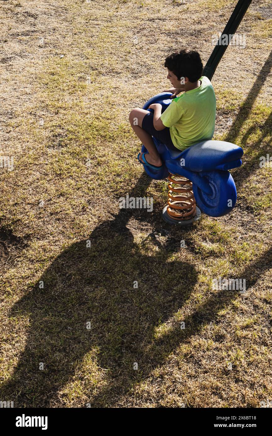 Child playing on a spring rider at an outdoor playground, enjoying a ...