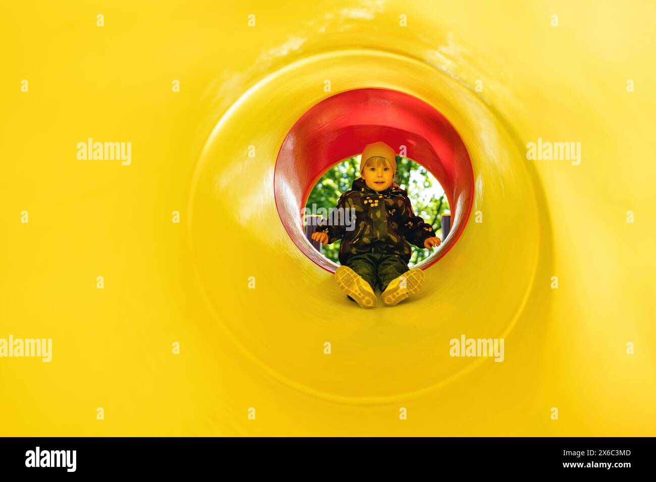 Active little girl inside a tube slide on playground. Cute little girl ...