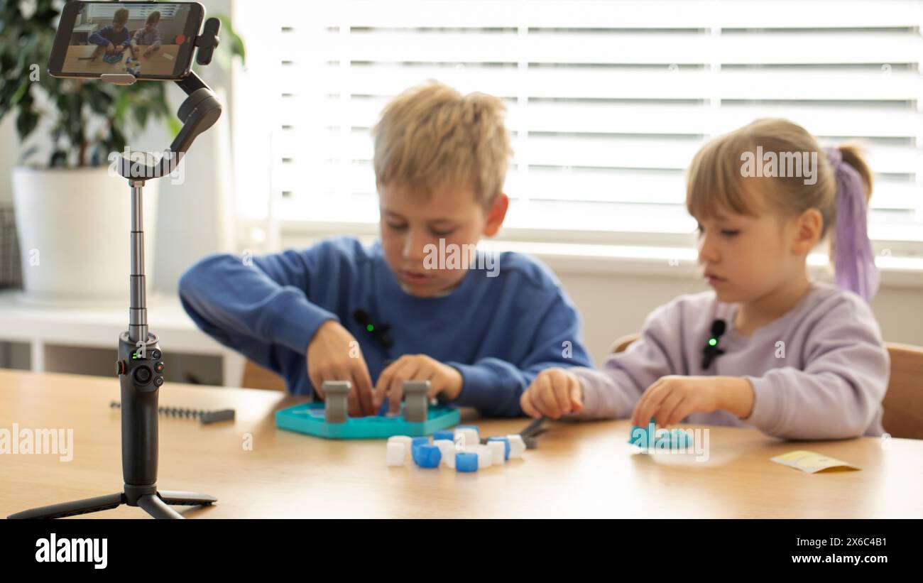 Kids play a new board game for their blog, recording a fun and ...