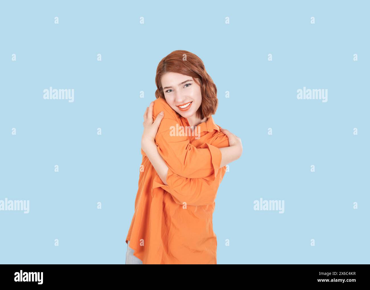 Close up portrait of caucasian red bob hair 20s woman hug herself ...