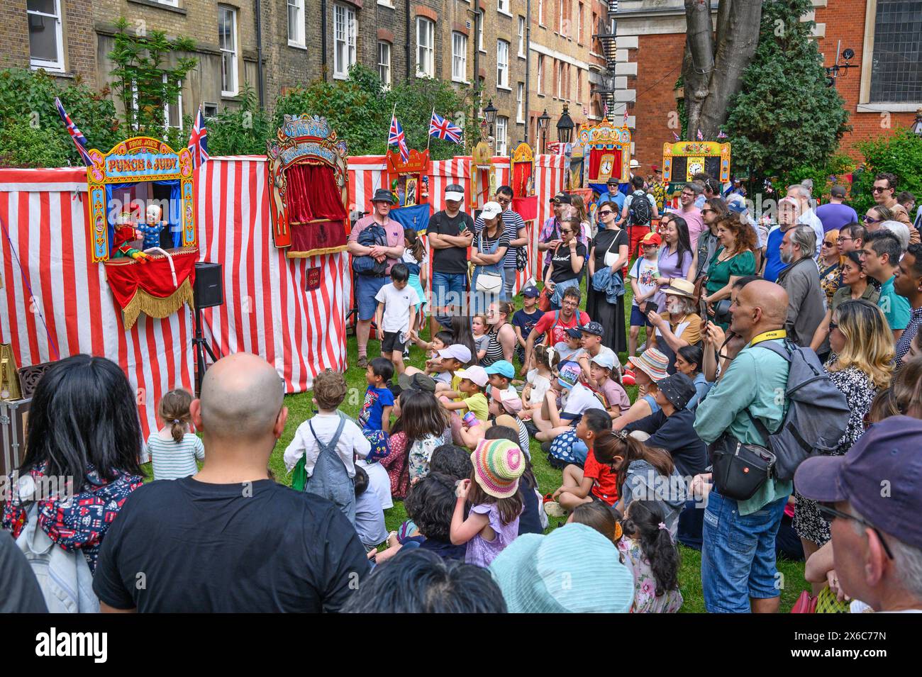 Crowd of children and adults watching a traditional Punch and Judy show ...