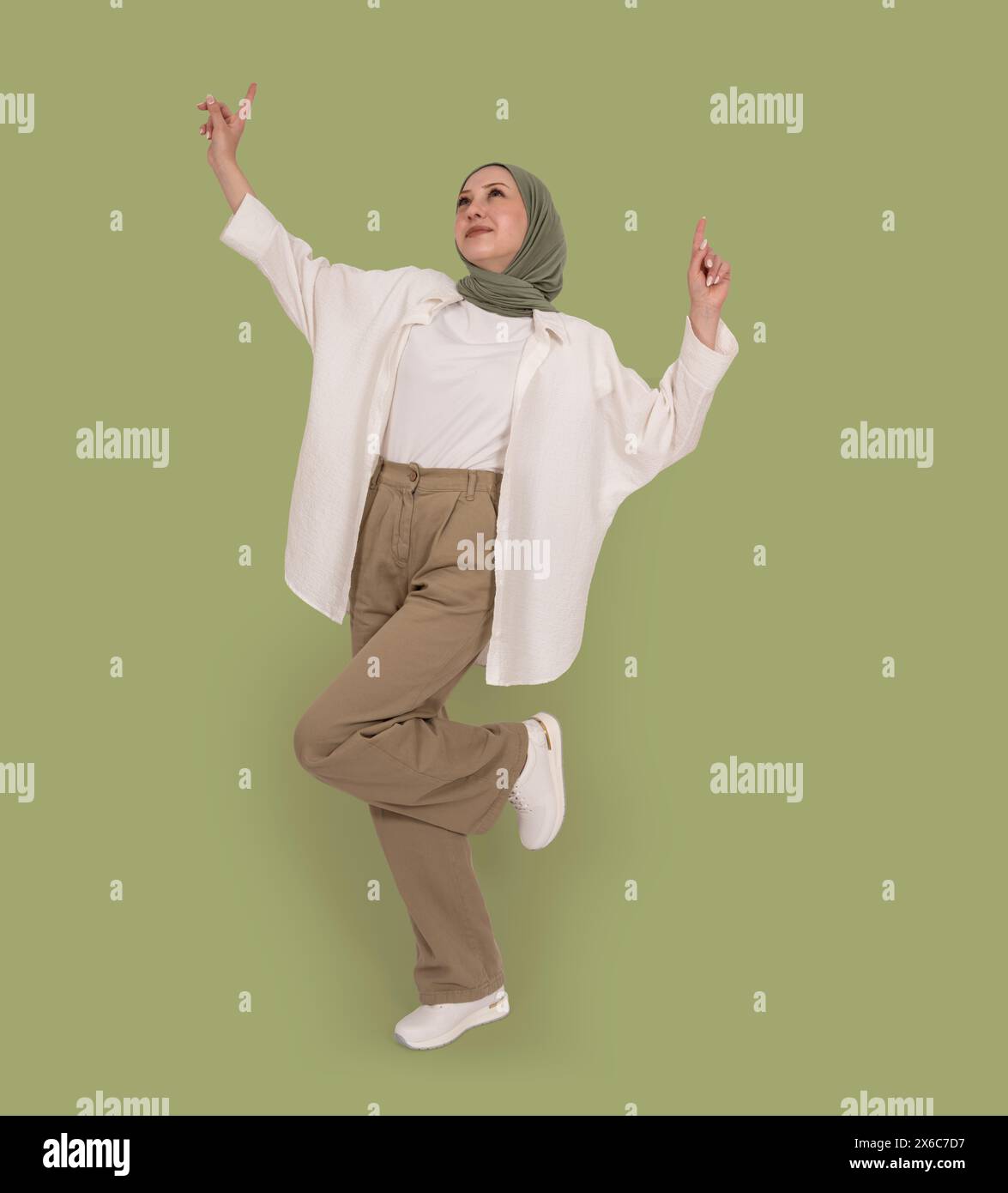 Full body young caucasian muslim woman, stand on one foot, outstretched ...