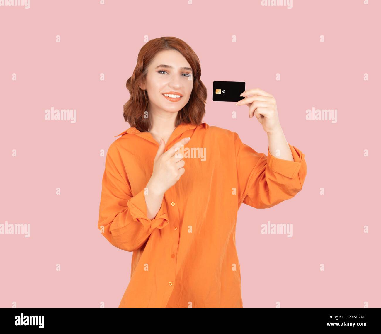 Portrait of beautiful sweet young woman pointing credit card. Holding ...