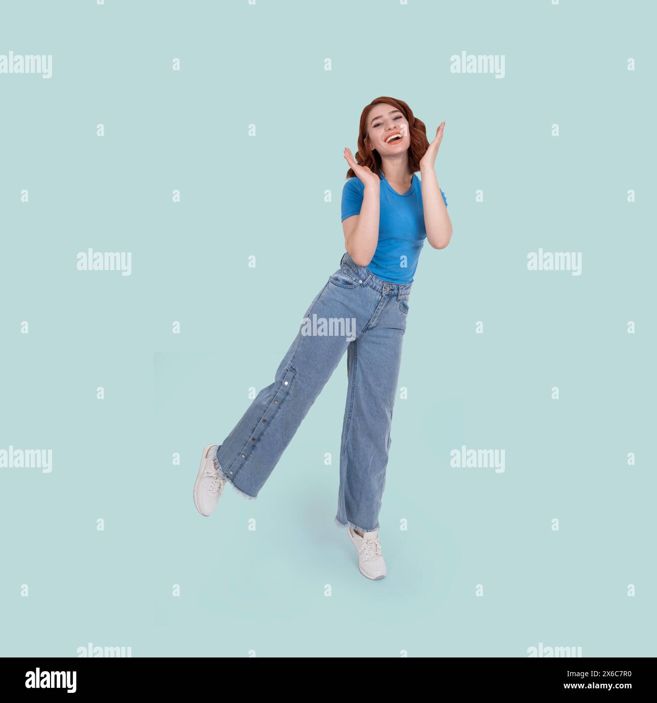 Studio portrait of young full body happy woman. Standing on one leg ...