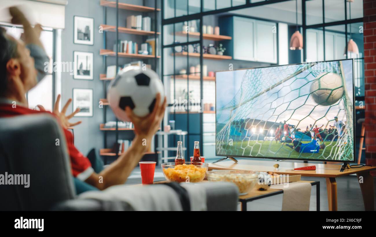 At Home Soccer Fans Sitting on a Couch Watch Football Game on TV, Cheer ...