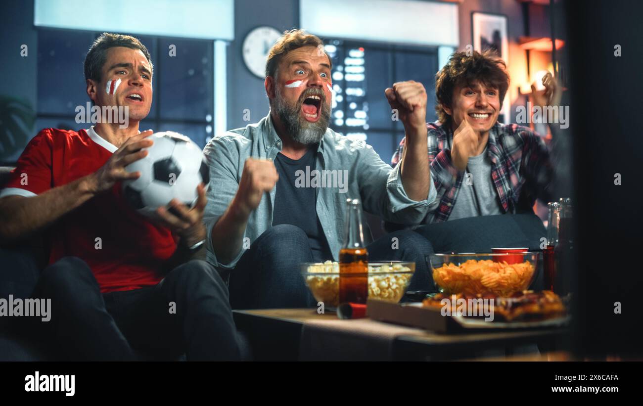 At Home Three Joyfuls Sports Fans with Painted Faces Sitting on a Couch ...