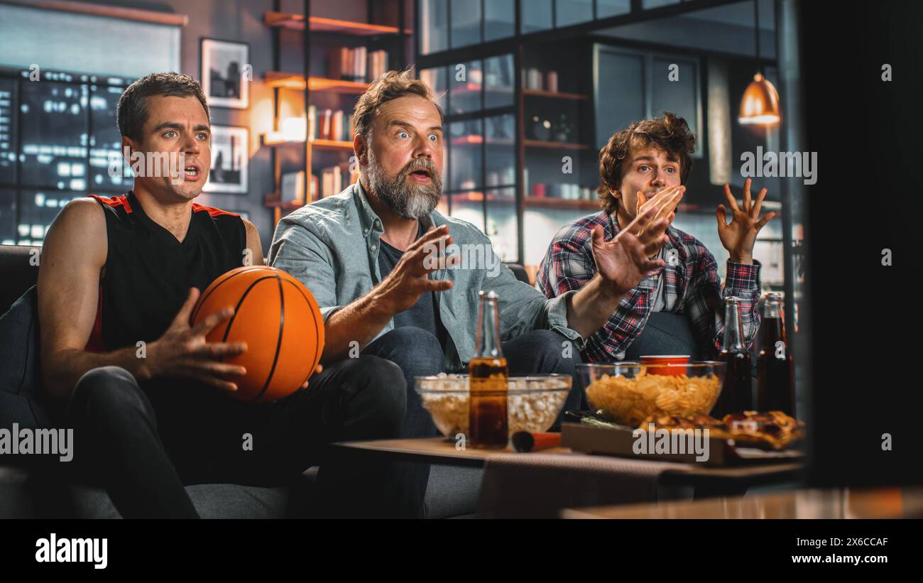 At Home Three Joyful Basketball Fans Sitting on a Couch Watch Game on ...