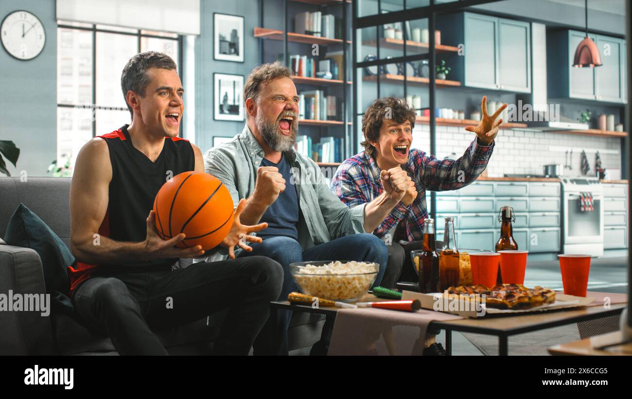 At Home Three Happy Basketball Fans Sitting on a Couch Watch Game on TV ...
