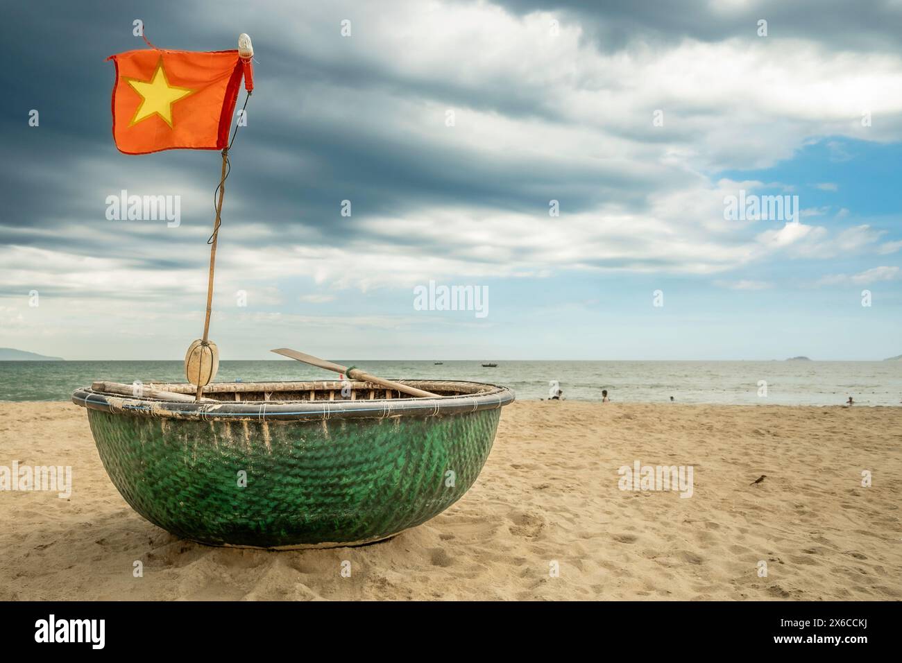 Traditional Vietnamese round fishing boat on the beach at Hoi An, with ...