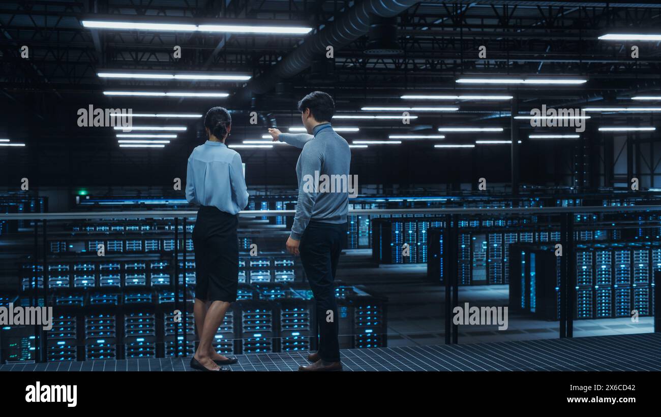 Data Center Female System Administrator and Male IT Specialist Talk ...