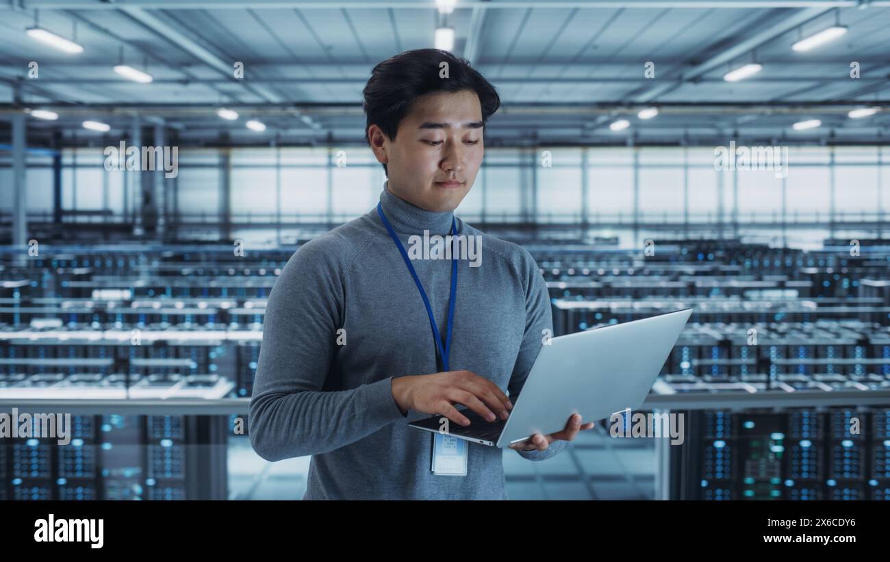 Portrait of a Data Center Engineer Using Laptop Computer. Server Room ...