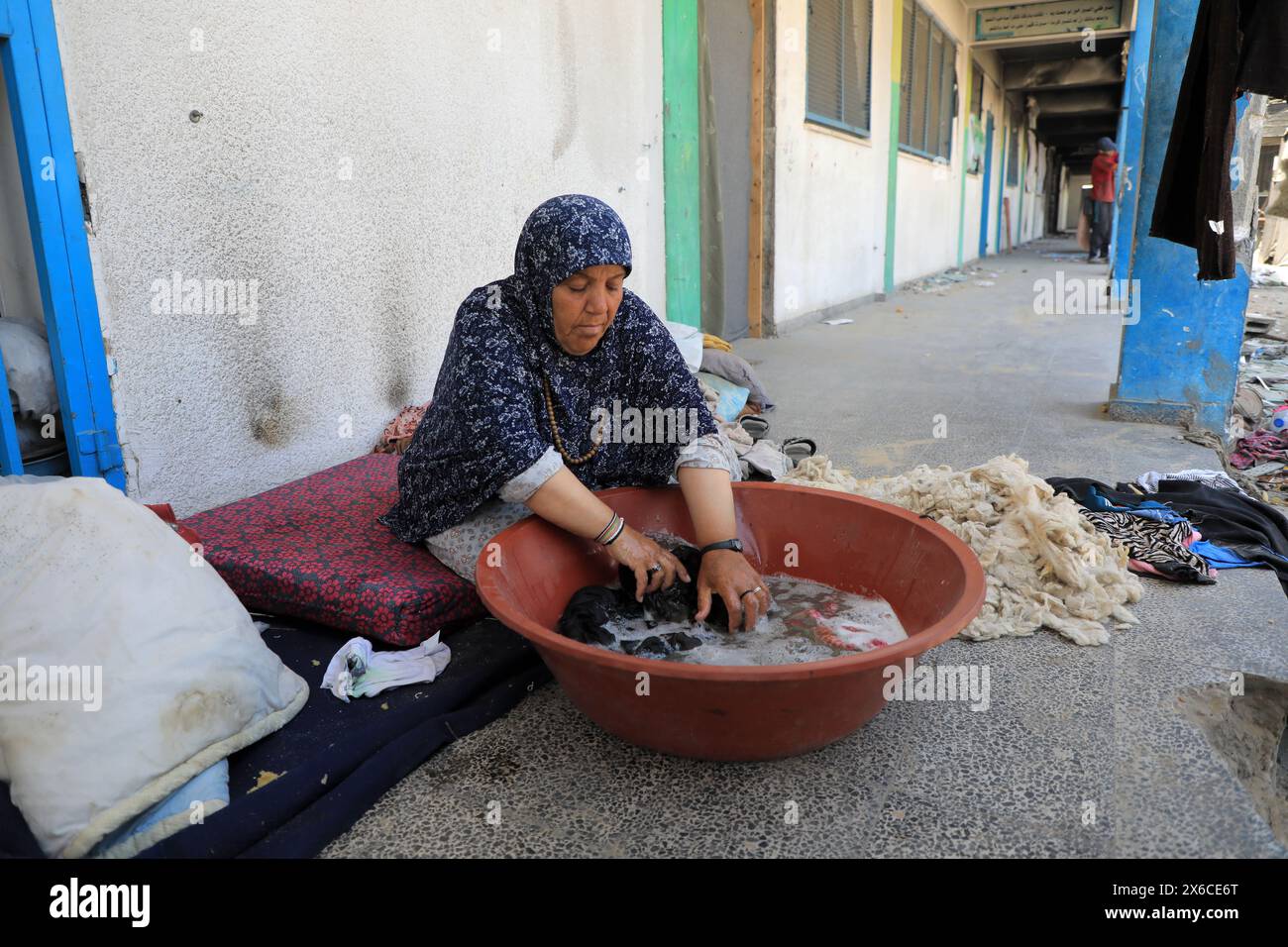 Khan Younis. 13th May, 2024. A Palestinian woman washes clothes at a ...