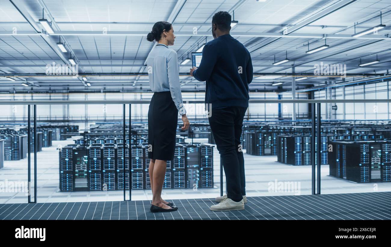 Data Center Female System Administrator and Male IT Specialist Talk ...