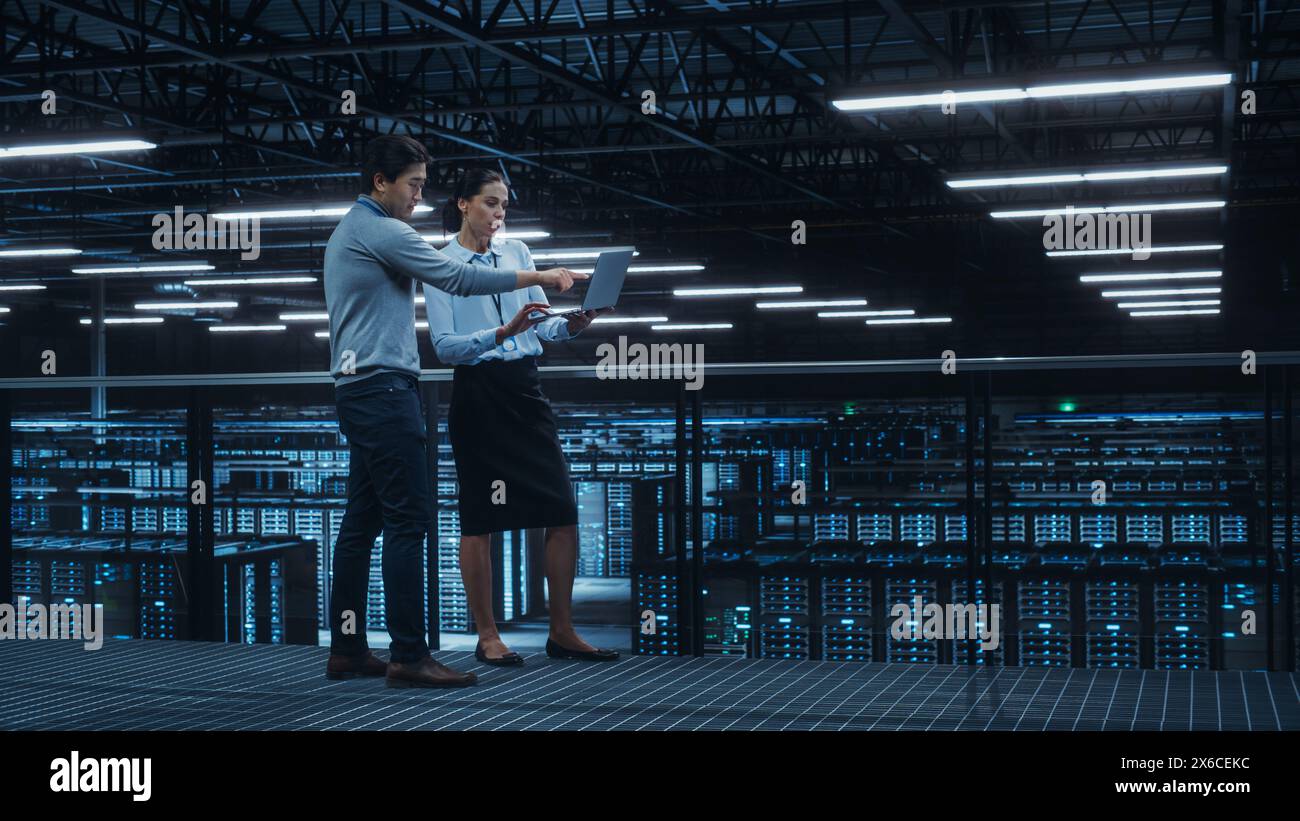 Data Center Female System Administrator and Male IT Specialist Talk ...