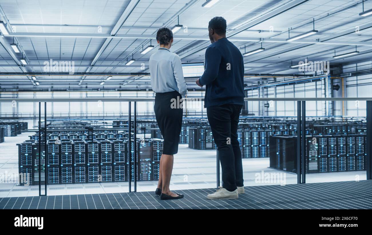 Data Center Female System Administrator and Male IT Specialist Talk ...