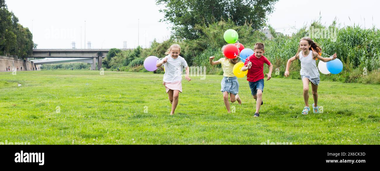 Children with balloons run in the summer park Stock Photo - Alamy