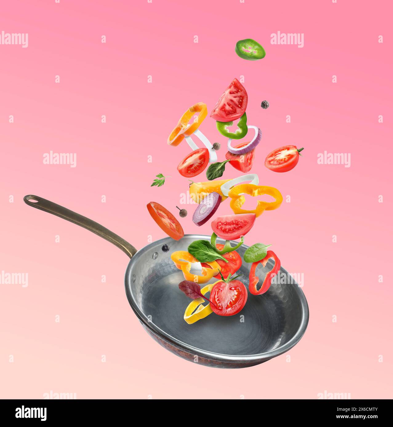 Frying pan and different vegetables in air on pink gradient background ...