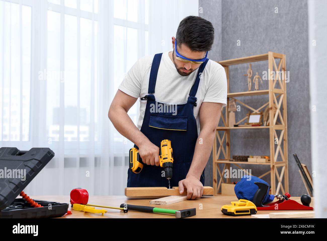 Young worker using drill hi-res stock photography and images - Alamy