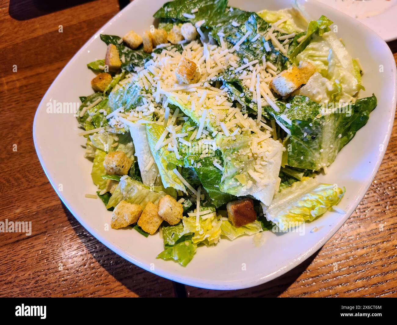 Fresh Caesar Salad in White Dish on Wooden Table, Eye-Level View Stock ...