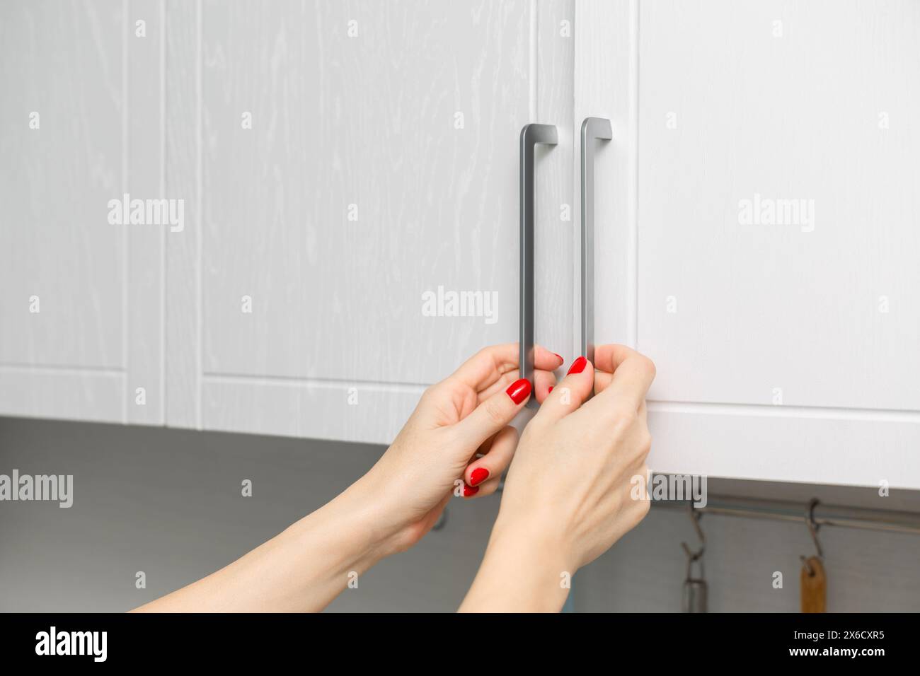 housewife opens kitchen cabinet doors with both hands, close-up. woman ...