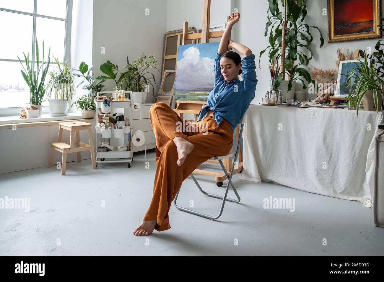 Female artist resting in home creative workspace. Woman enjoys quiet ...