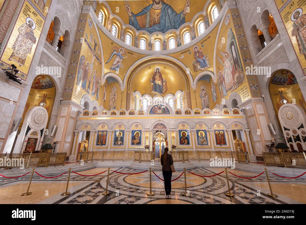 A woman inside the extremely ornate and decorative interior of St Sava ...
