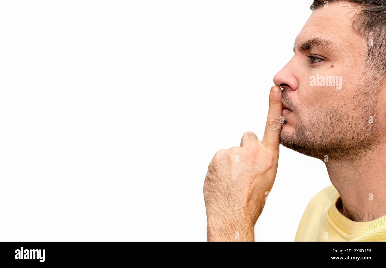 Stop talking gesture. Shushing or shh. Man holds his index finger on ...