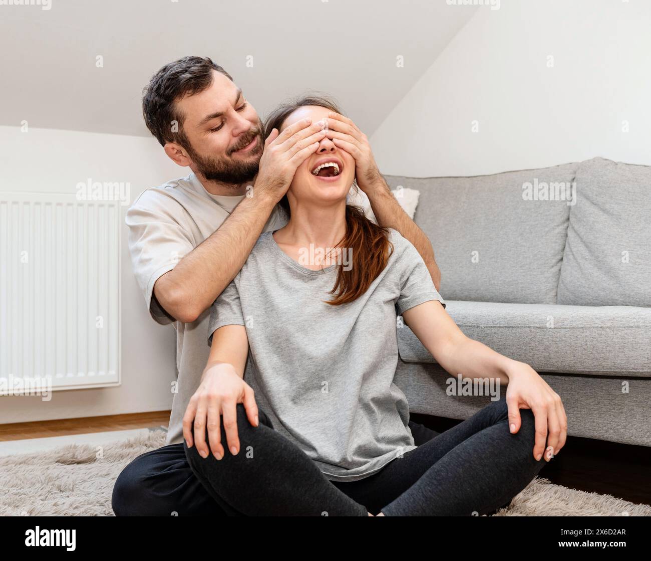 Making a surprise. Couple in love at home Stock Photo - Alamy