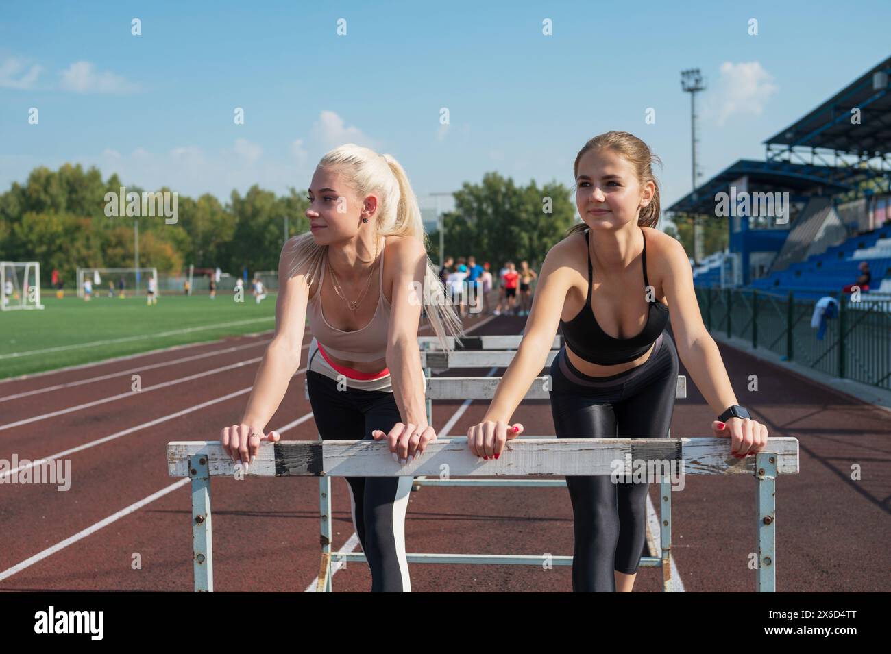 Two friends - athlete young woman runner train at the stadium outdoors ...
