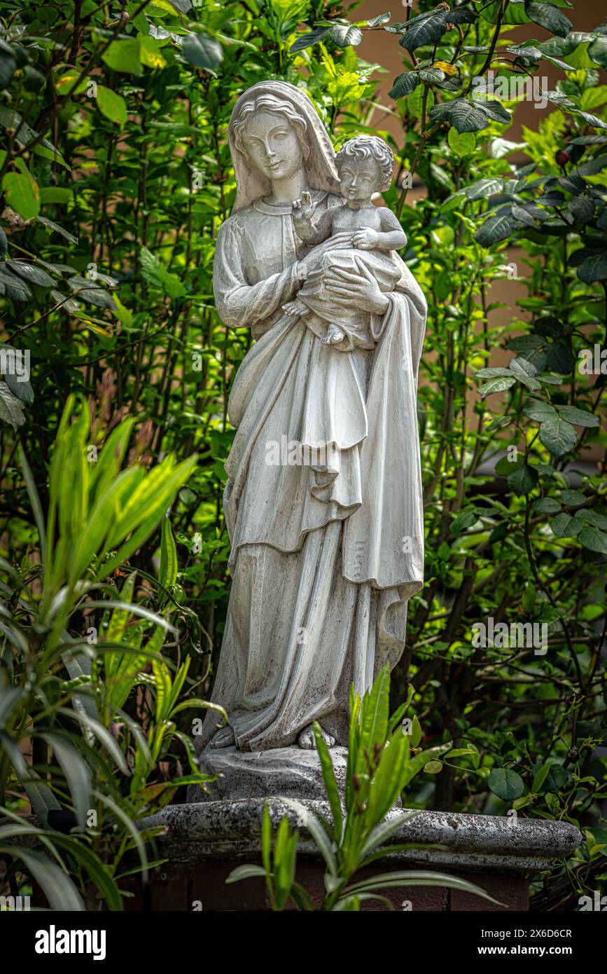 Statue of the Madonna with child in a rose garden. Abruzzo, Italy ...