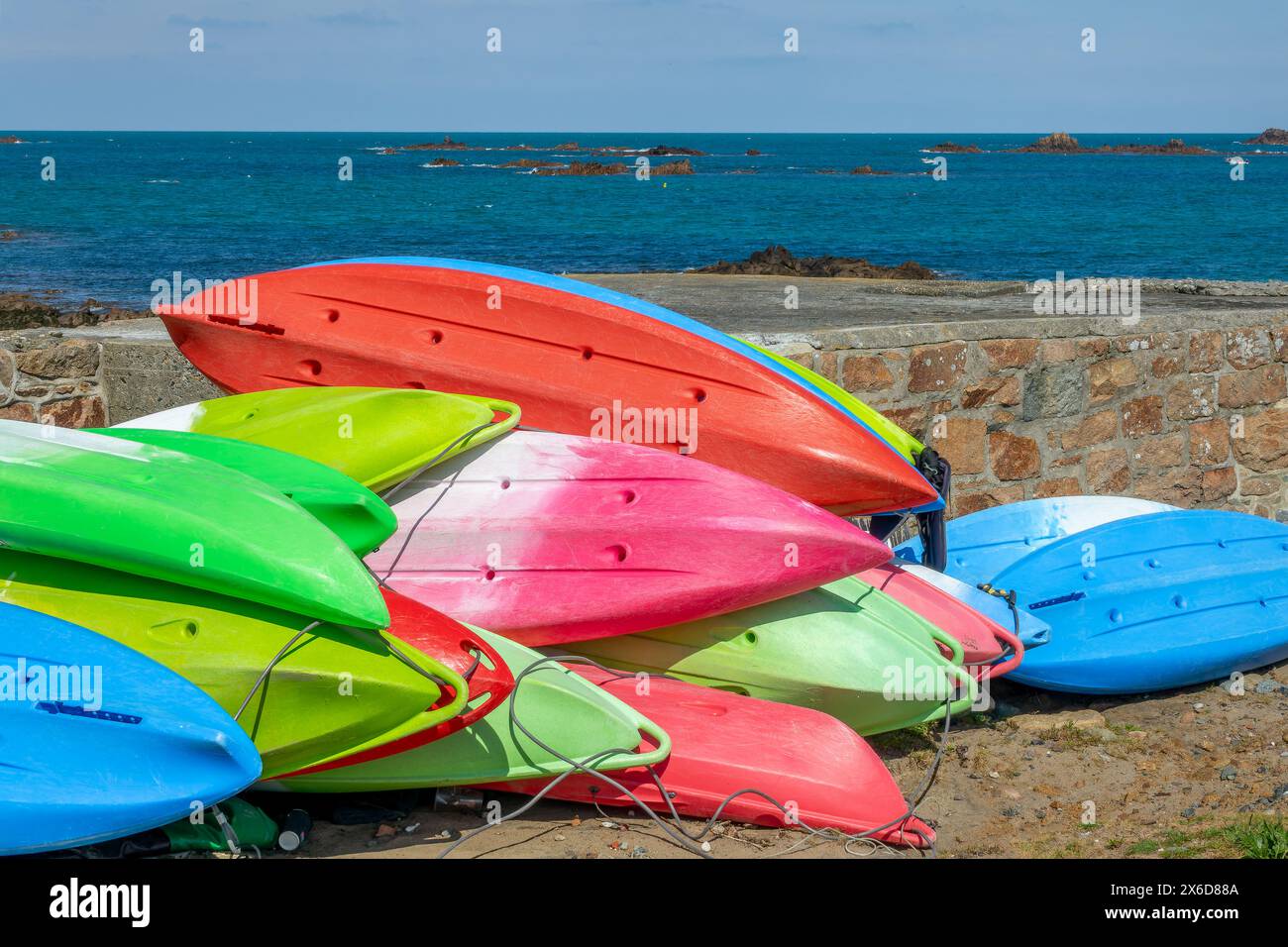 Colorful sea kayaks on the shore in Cobo bay, Guernsey, CHannel Islands ...