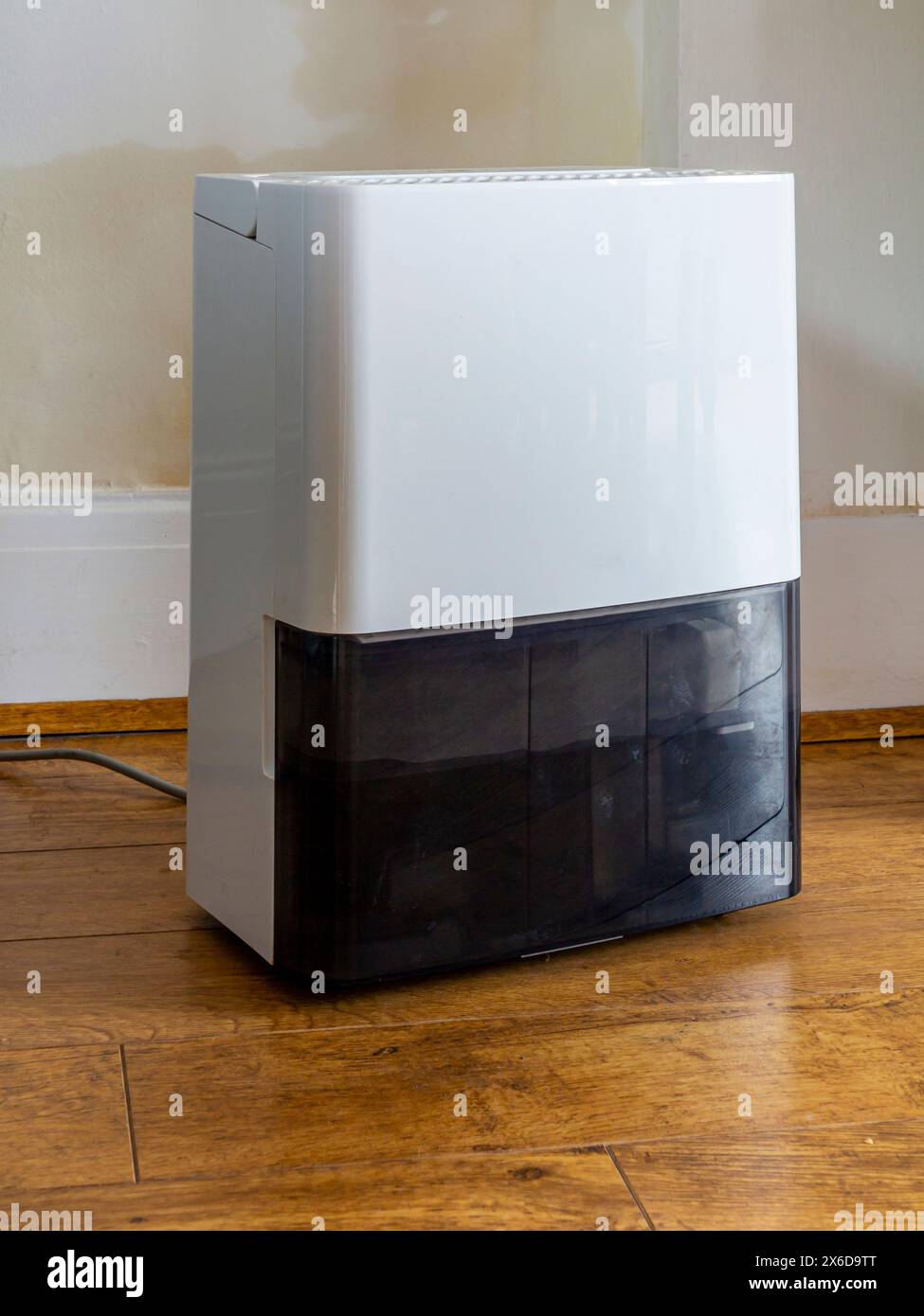 Domestic dehumidifier unit being used in a room to remove excess damp ...