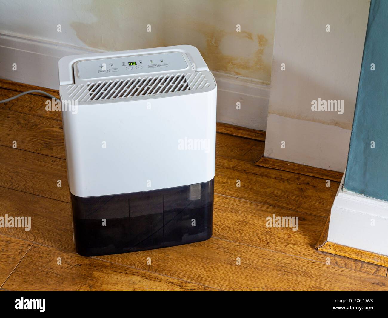 Domestic dehumidifier unit being used in a room to remove excess damp ...
