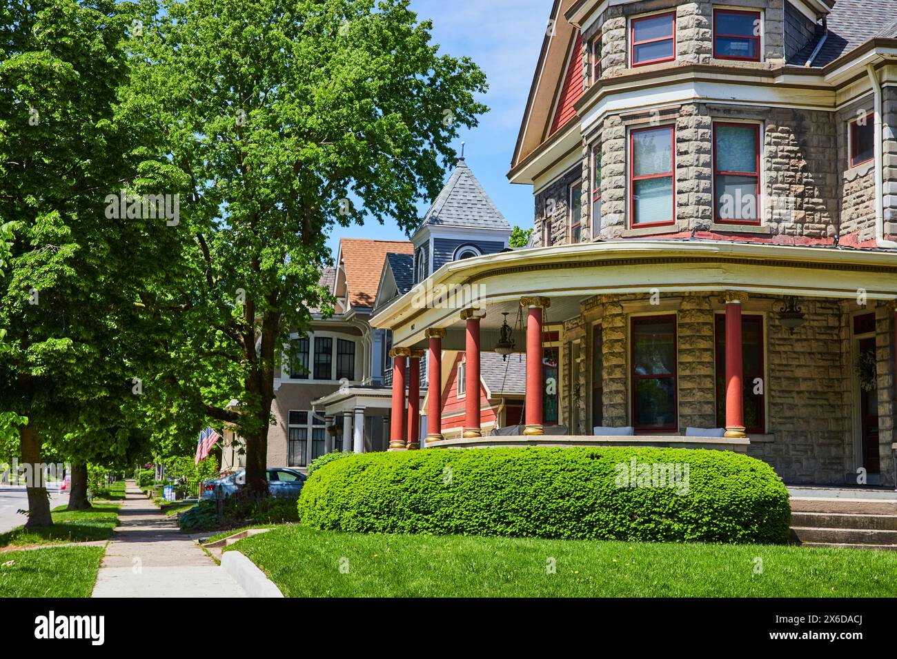 Historic Stone House with Red Columns in Lush Suburban Street, Eye ...