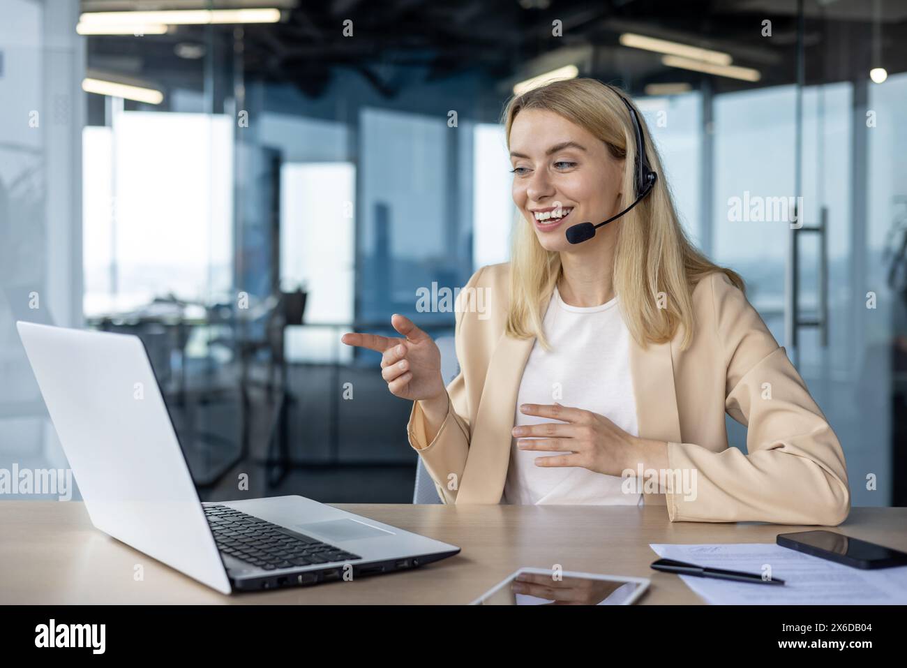 A professional woman with a headset engaging in a video call at her ...