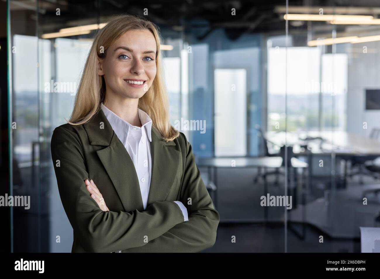A young professional woman with a pleasant smile stands confidently in ...